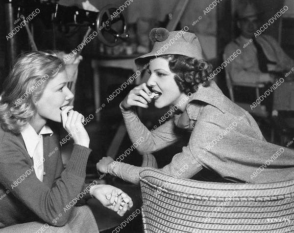 candid Elissa Landi and friend eating peanuts between the scenes film ...